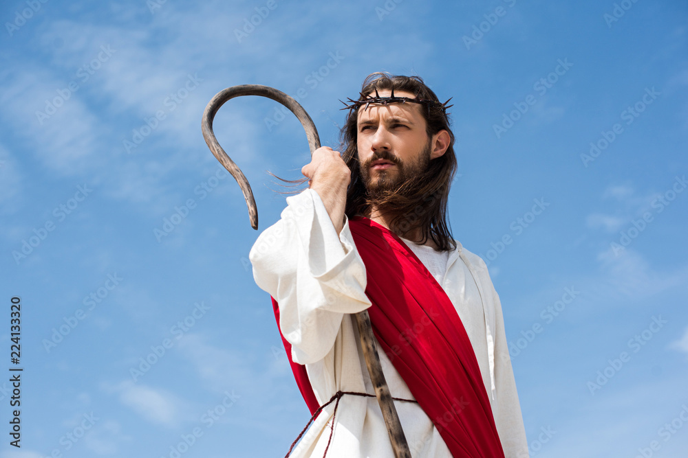 Jesus in robe, red sash and crown of thorns standing with wooden staff ...