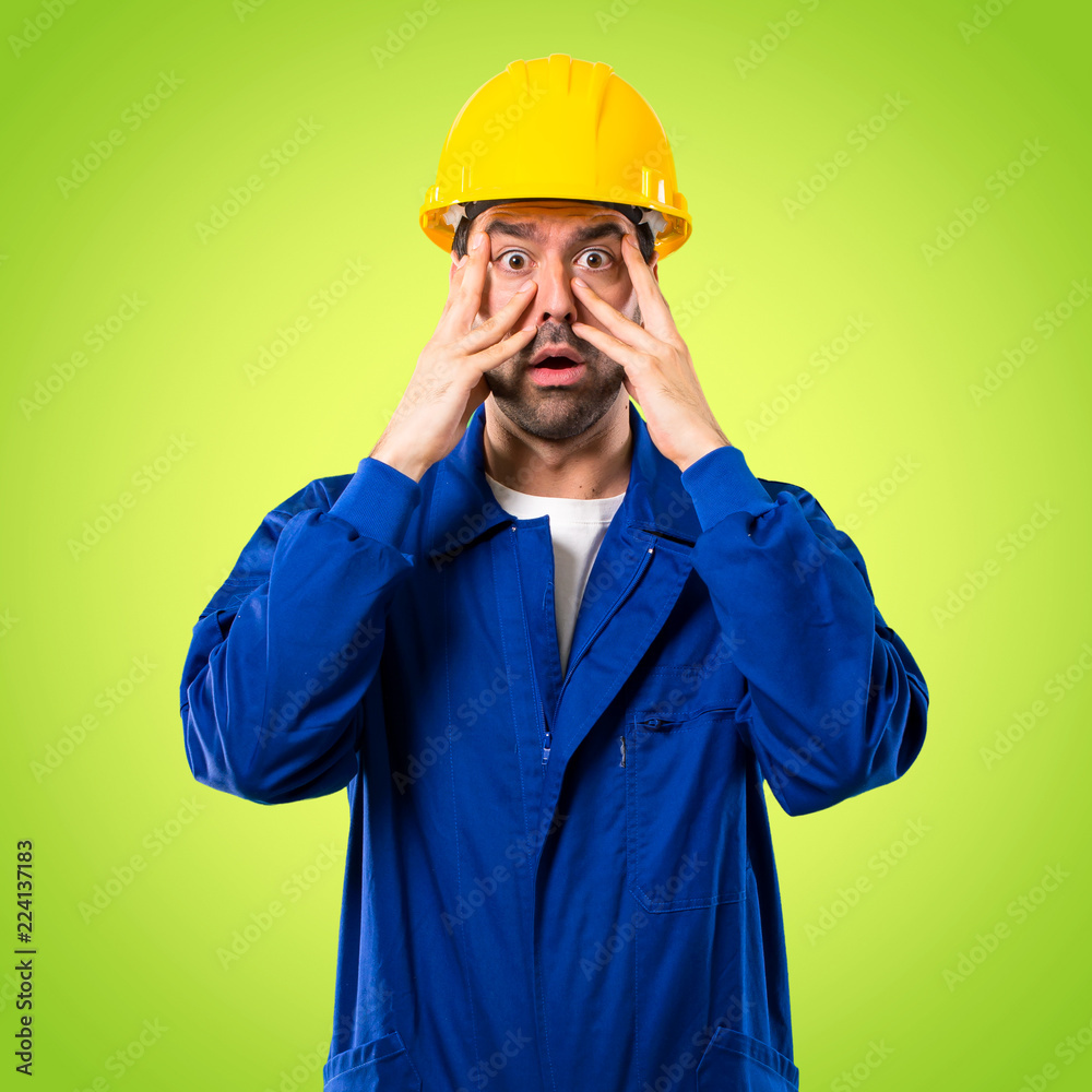 Young workman with helmet surprised and covering face with hands while ...