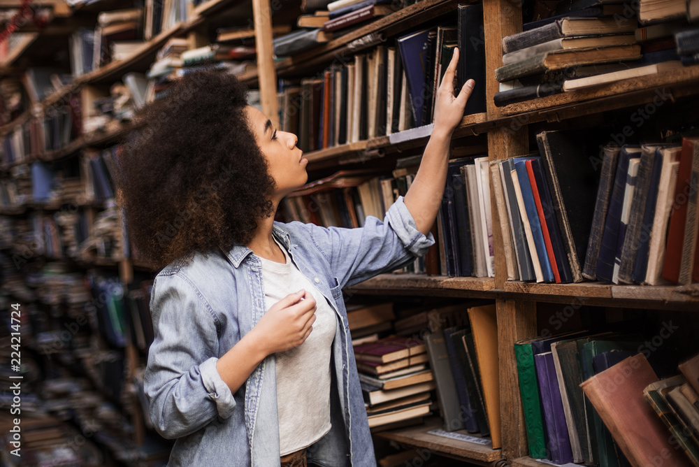 Foto de Young female african american librarian making order on ...