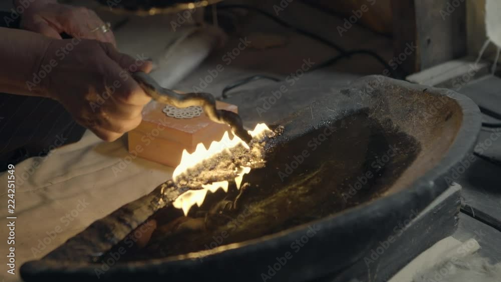 Traditional Inuit Elder siting inside a Tupiq lites a Kudlik ...