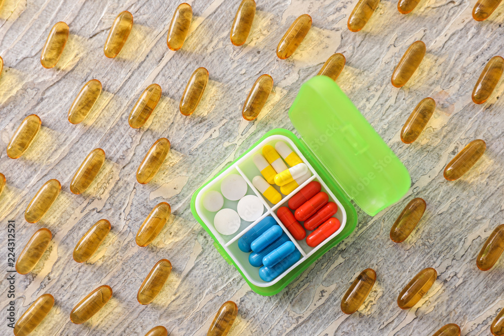 Plastic container with pills on table Stock Photo | Adobe Stock