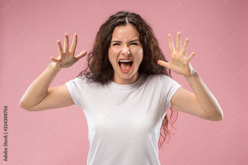 Angry woman. Aggressive business woman standing isolated on trendy pink ...