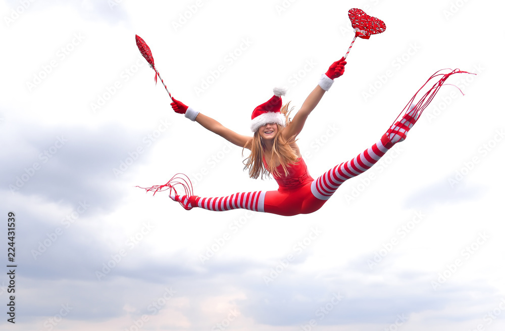 A young girl wearing a Santa Claus hat shows her happy feelings for ...