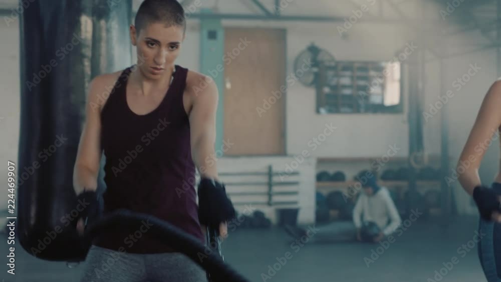 fitness women athletes training using battle ropes team exercise ...