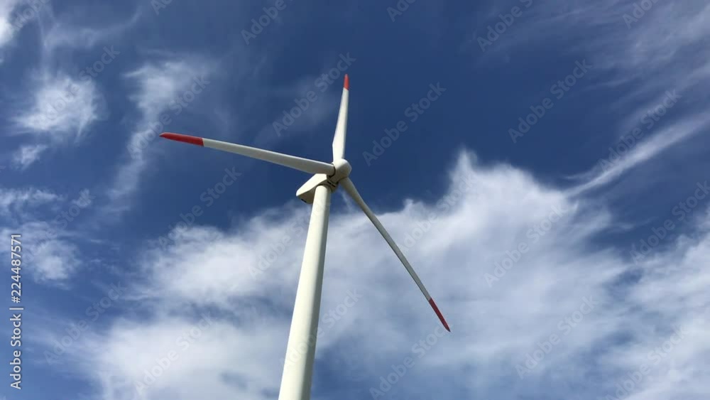 Closeup front back footage of a giant wind turbine with three blades ...