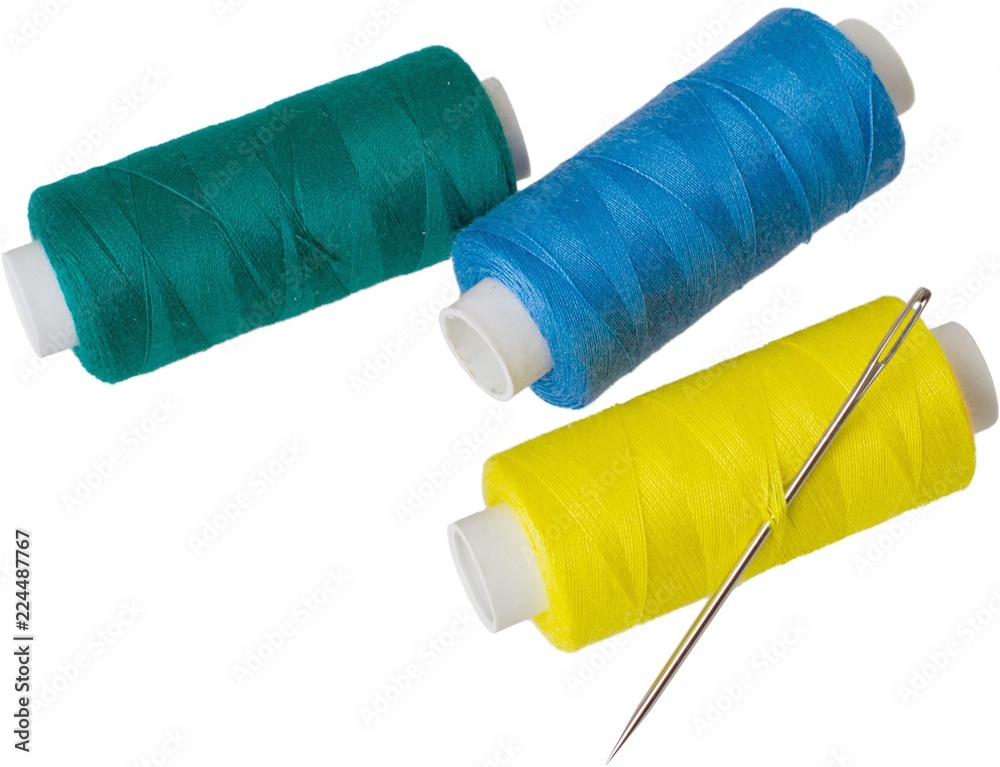 Spools of thread and a sewing needle Stock Photo | Adobe Stock