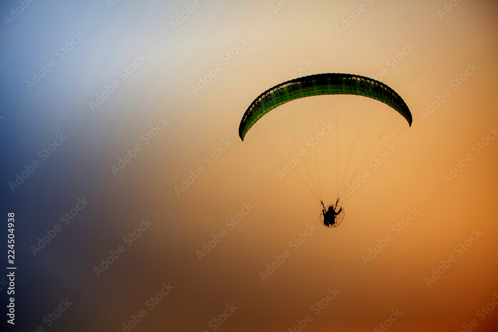 Skydiving sunset landscape of parachutist flying in soft focus. Para ...