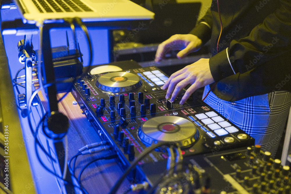 DJ plays and mix music on digital mixer controller. Close-up DJ ...