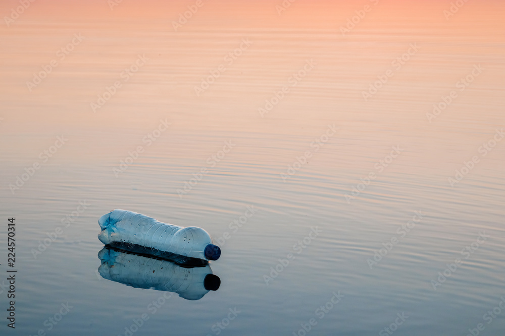 Concept of pollution, creative background. A plastic bottle floating in ...