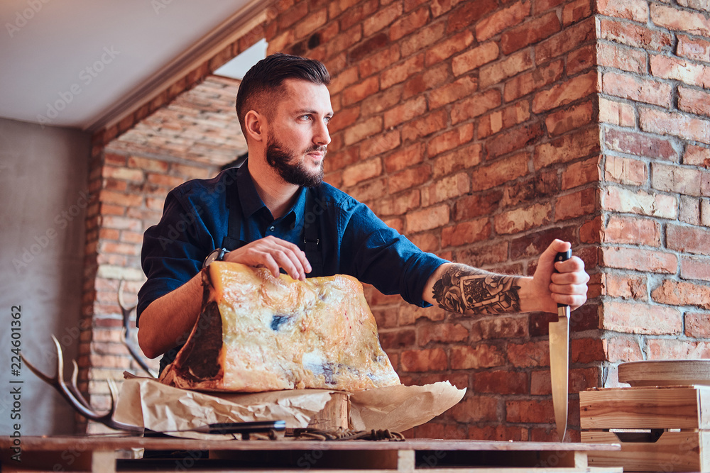Chef cook holds knife and posing near a table with exclusive jerky meat ...