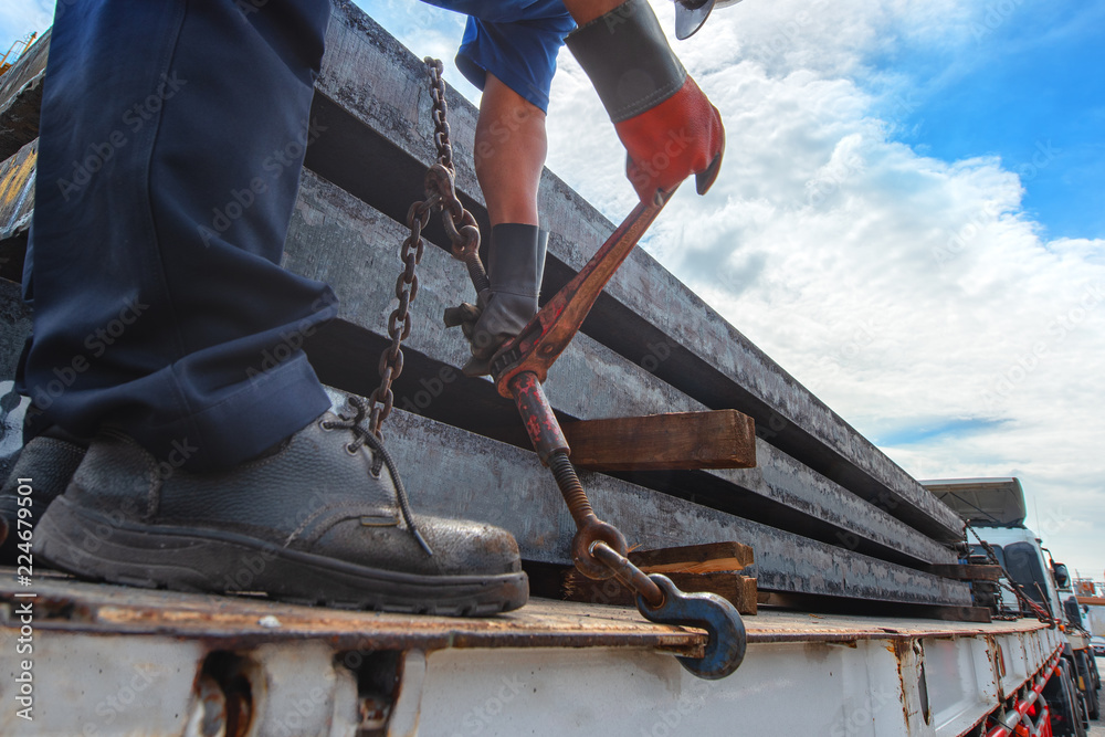 workers driver of the trailer lorry is lashing securing steel slab on ...