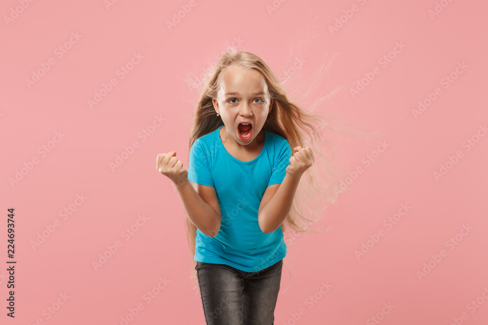 Angry teen girl standing on trendy pink studio background. Female half ...