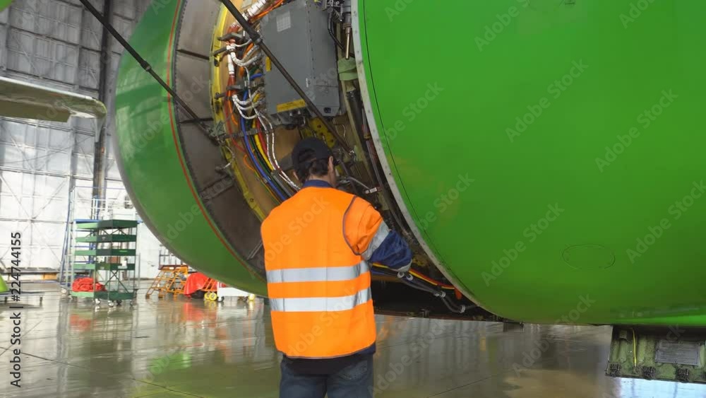Maintenance of passenger aircraft. Engineer checks the aircraft engine ...