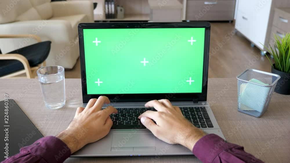 Male hands typing on the laptop keyboard with chroma green screen mock ...