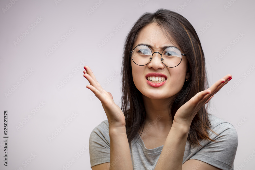 Close up isolated portrait of young annoyed angry Asian woman holding ...