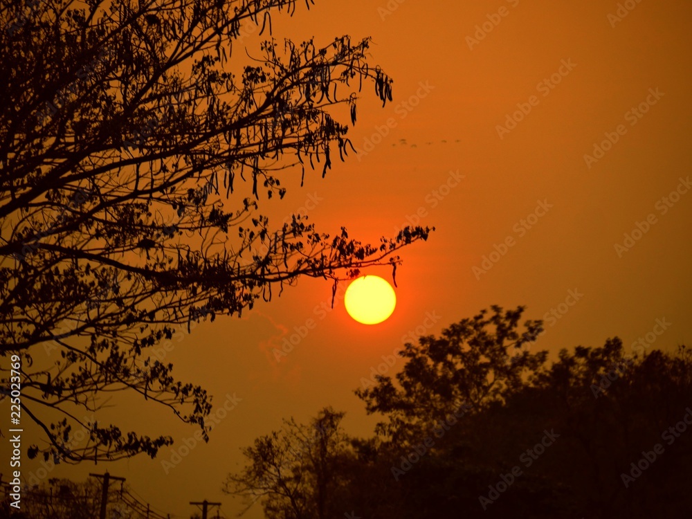 Forced perspective of a round sunset looking like it's suspended from a ...
