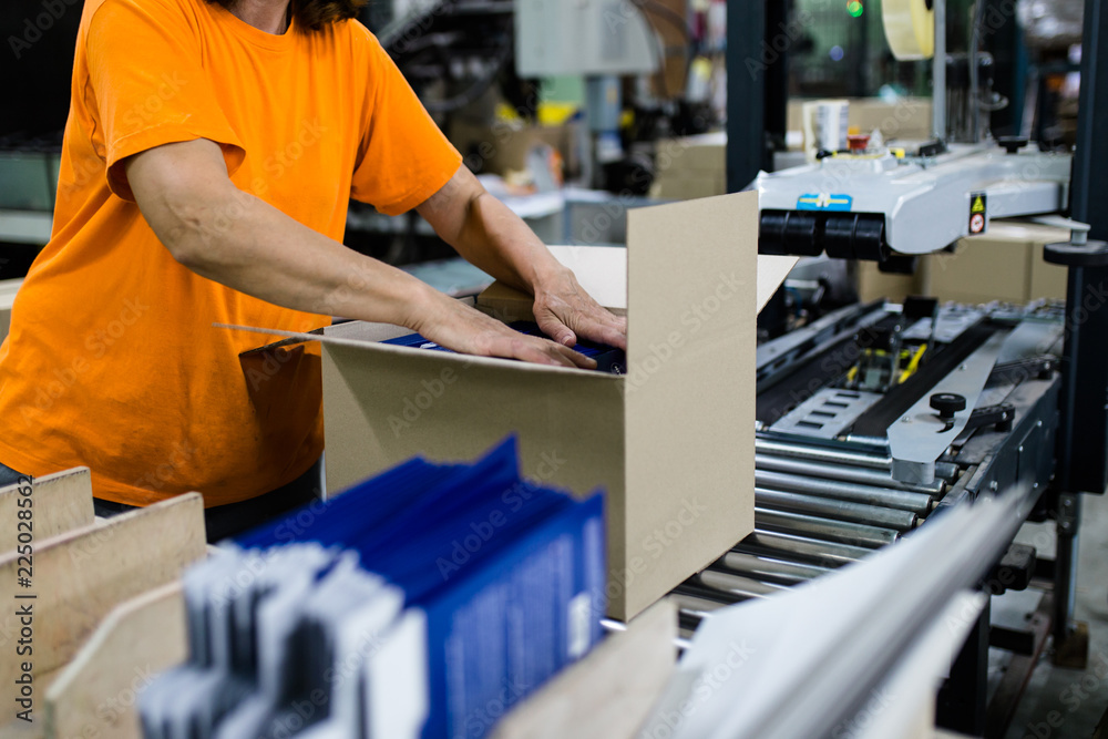 Close up shot of worker's hand preparing carton for printing in a ...