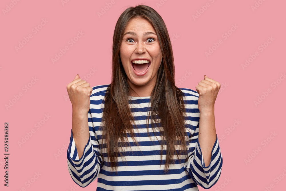 Thats great! Successful businesswoman raises clenched fists, dressed in ... Thats great! Successful businesswoman raises clenched fists, dressed in ...