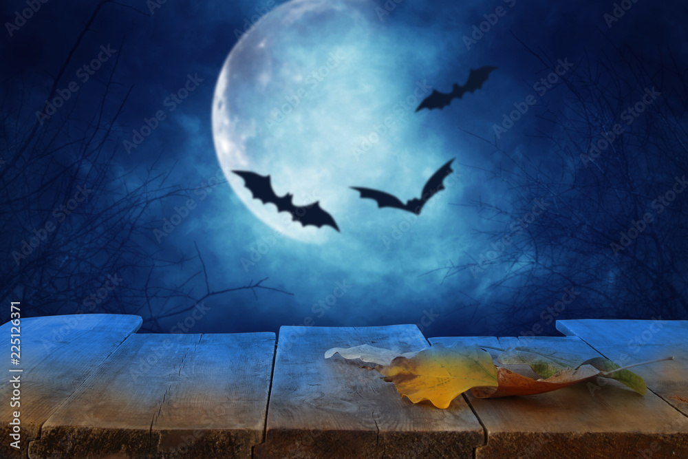 Halloween holiday concept. Empty rustic table in front of scary and ...