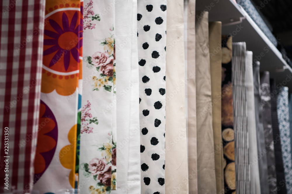 Colorful curtain samples hanging from hangers on rail in a display ...