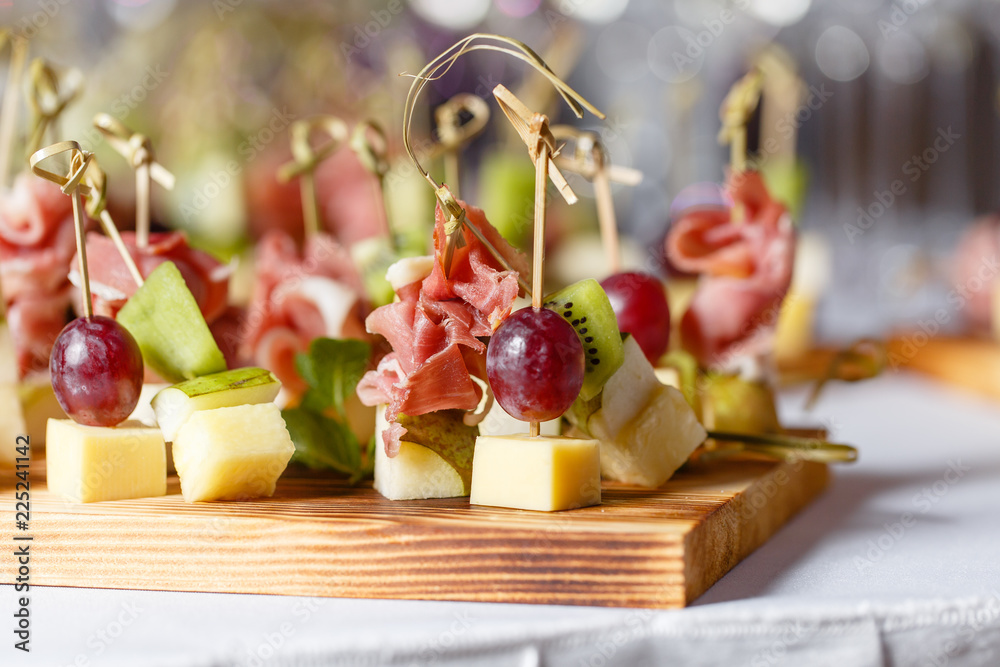Light snacks in a plate on a buffet table. Assorted mini canapes ...
