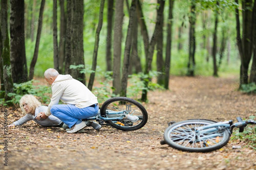 Senior man helping his wife to raise up from ground after she fell off ...