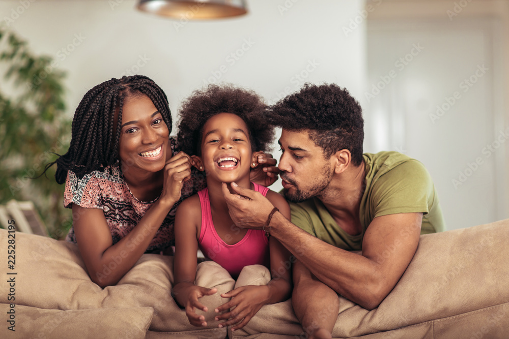 Happy family posing on the couch together at home in the living room ...