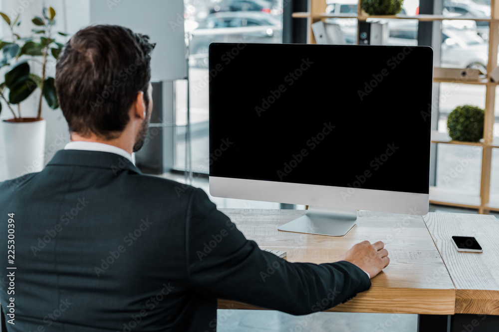 back view of businessman at workplace with computer screen with blank ...
