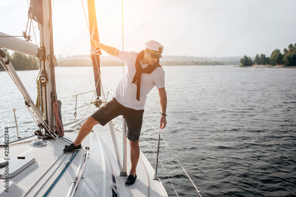 Beautiful icture of handsome and serious sailor standing on his yacht ...
