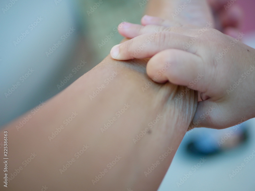 Baby's hand, 17 months old, pinching and pulling her father's arm skin ...