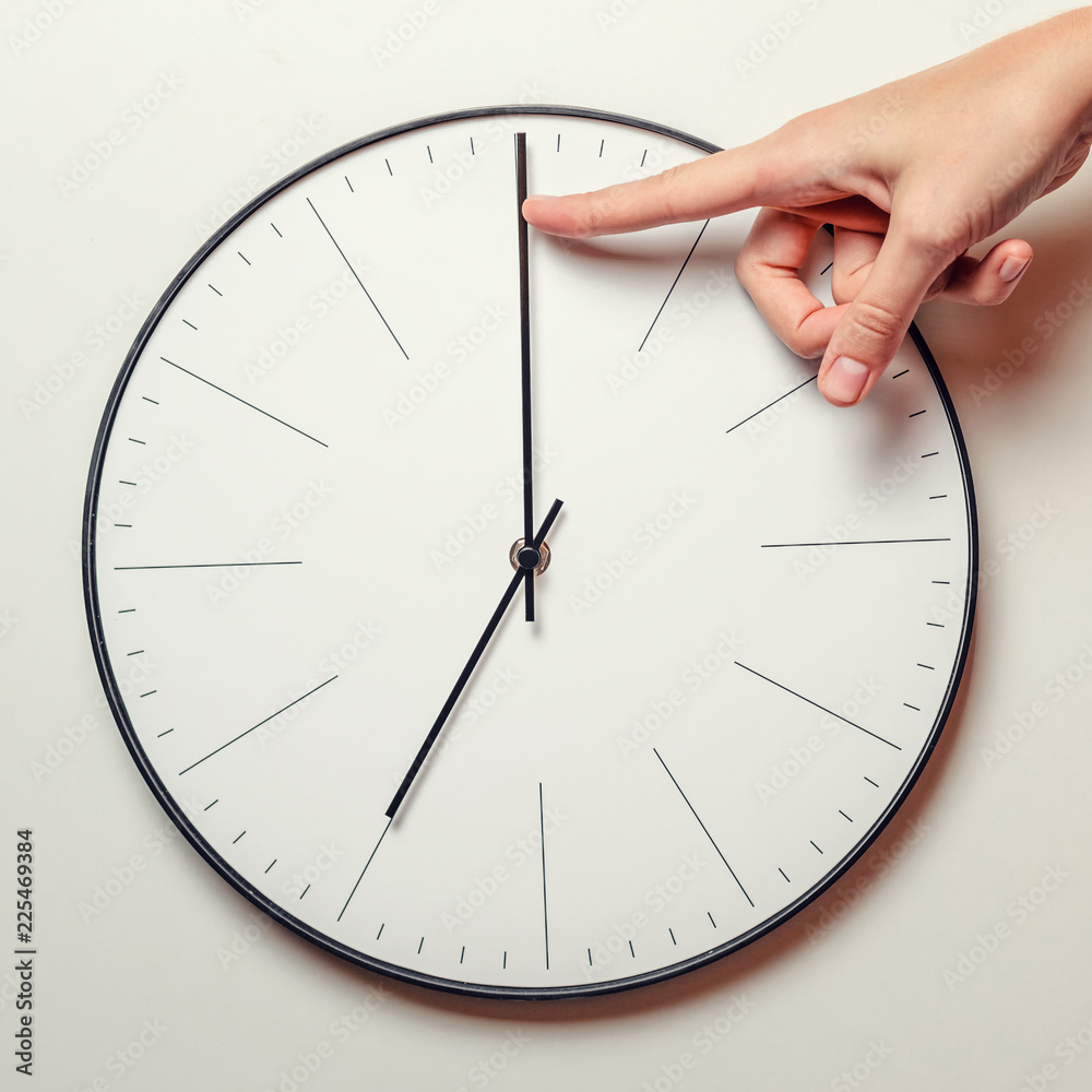 Foto de Woman hand stop time on a round clock, female finger takes the ...