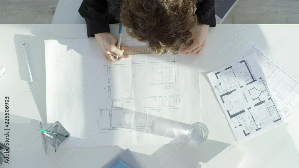 Top view of concentrated female engineer or designer creating technical ...