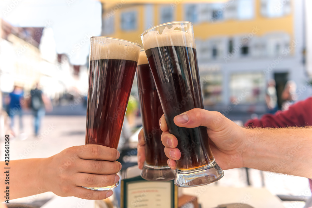 Toasting with beer in a beer garden in the market place. Concept: food ...