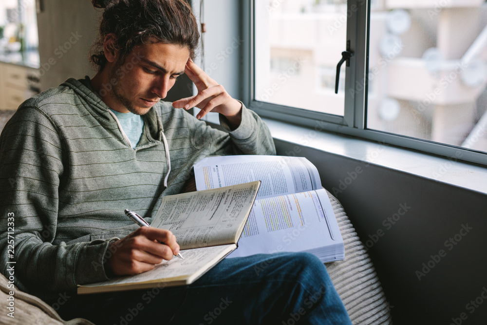 College student writing notes sitting at home Stock Photo | Adobe Stock