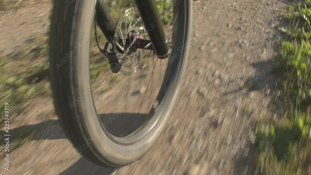 Loop of CLOSE UP: E-bike wheel and big mountainbike tire spinning fast ...