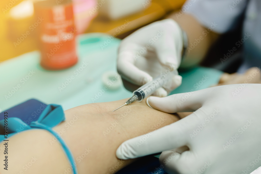 Selective and close up nurse pricking needle syringe in the arm patient ...