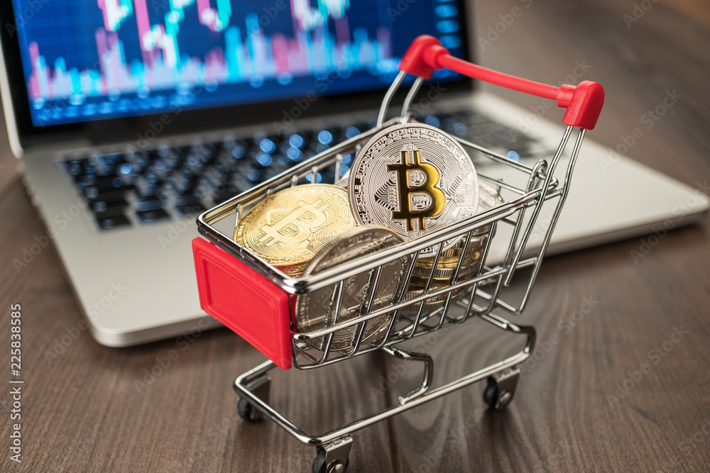 shopping trolley full of bitcoin currency with laptop showing stock ...