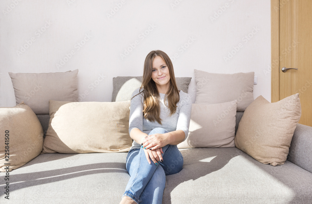 1 white girl with long hair in jeans sitting on the couch, girl smiling ...