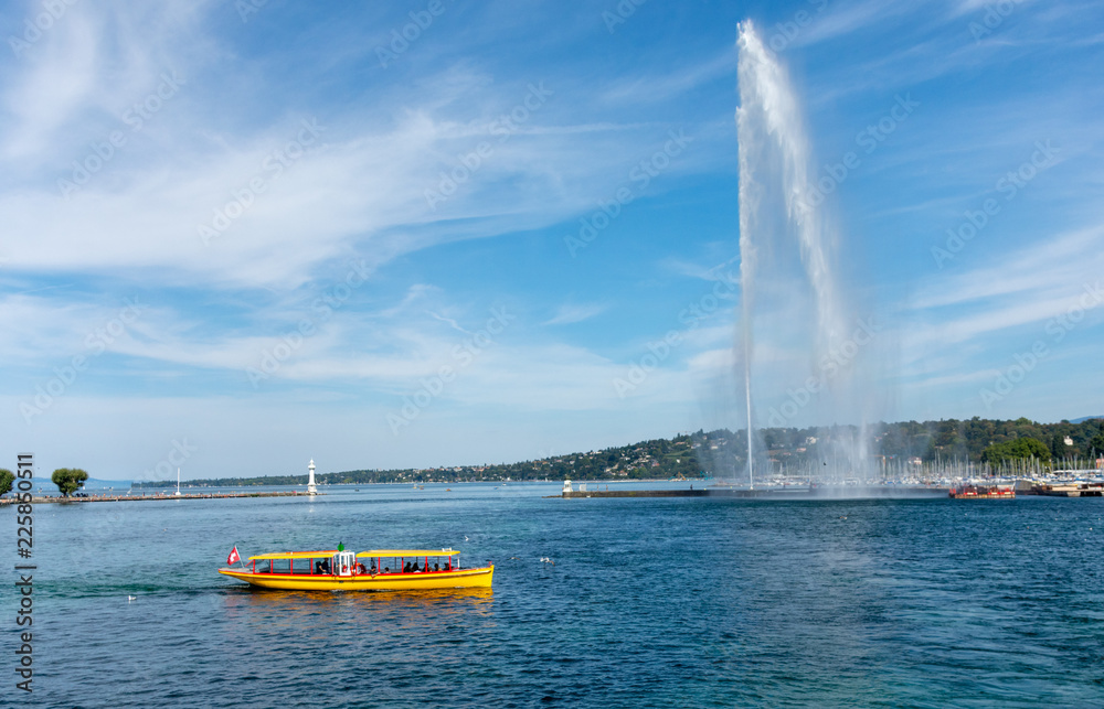 The Jet d'eau, landmark of the city of Geneva, with a yellow taxi boat in front. 500l water/s ...