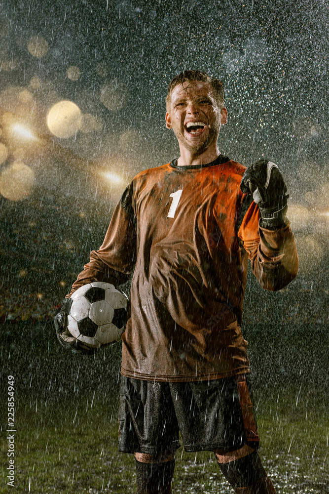 Soccer player on professional soccer night rain stadium. Dirty player ...