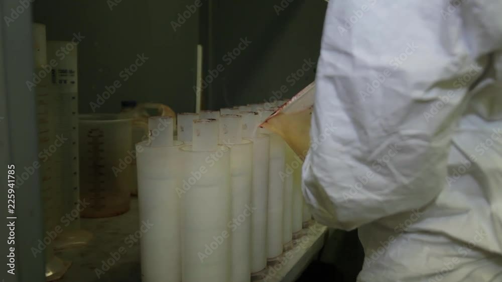 Rows of light plastic cylindrical water filters are being filled in ...