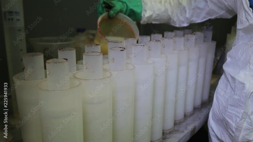 Rows of light plastic cylindrical water filters are being filled in ...