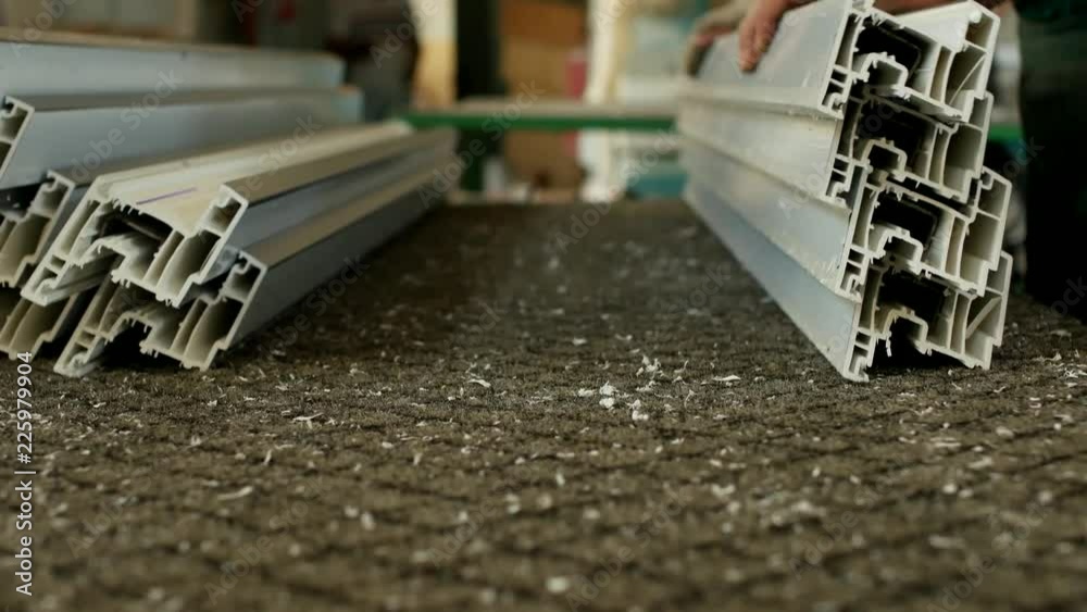 Production of pvc windows, male worker punctures the details of a pvc ...