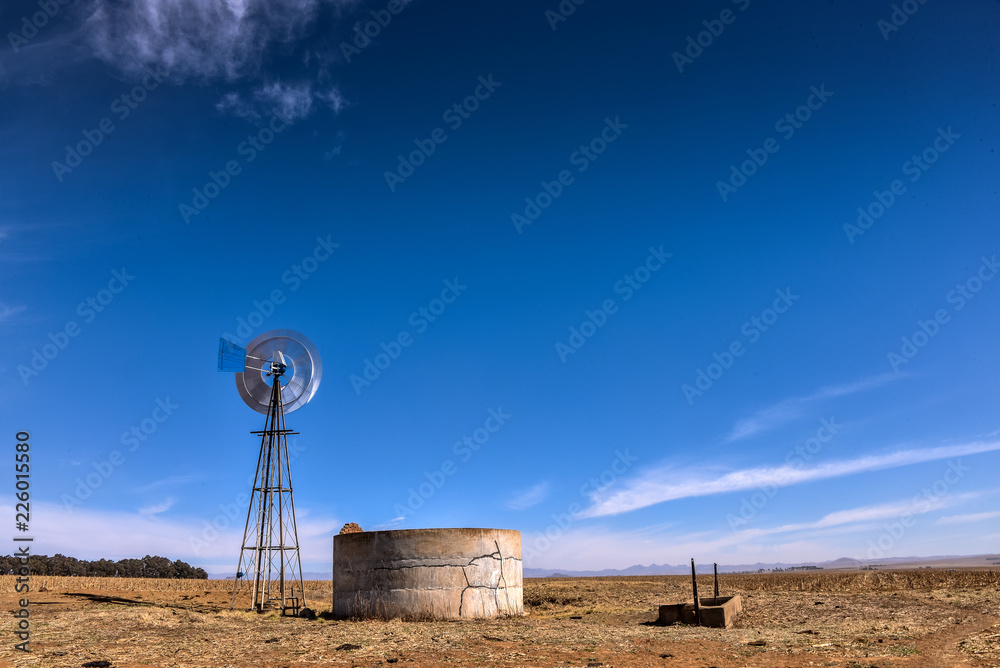 Windmill and small concrete dam in dry farm landscape Stock Photo ...