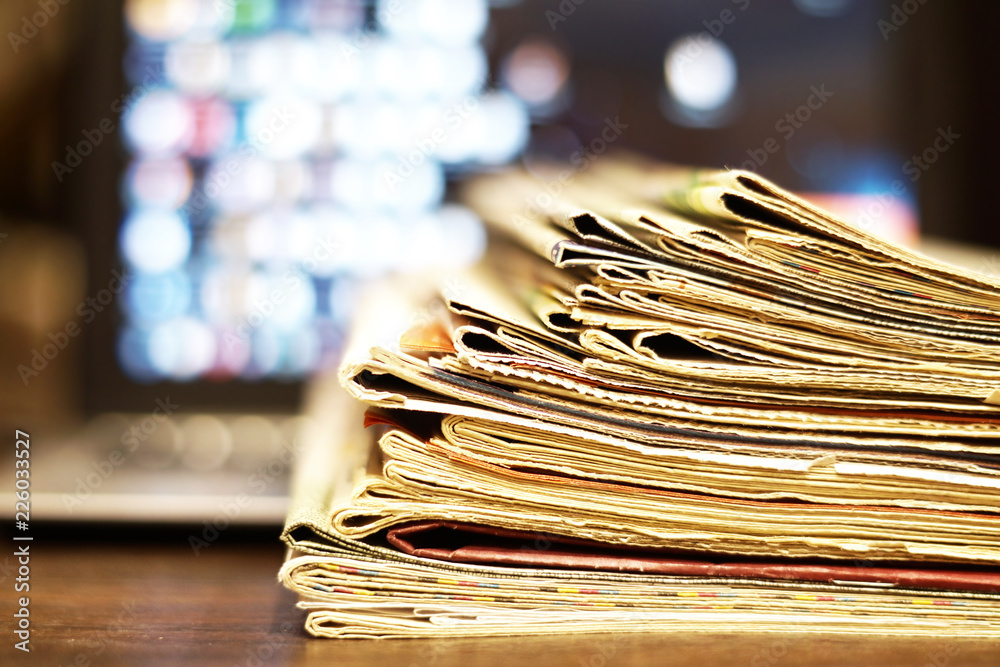 Stack of newspapers and laptop. Daily journals with news and personal ...