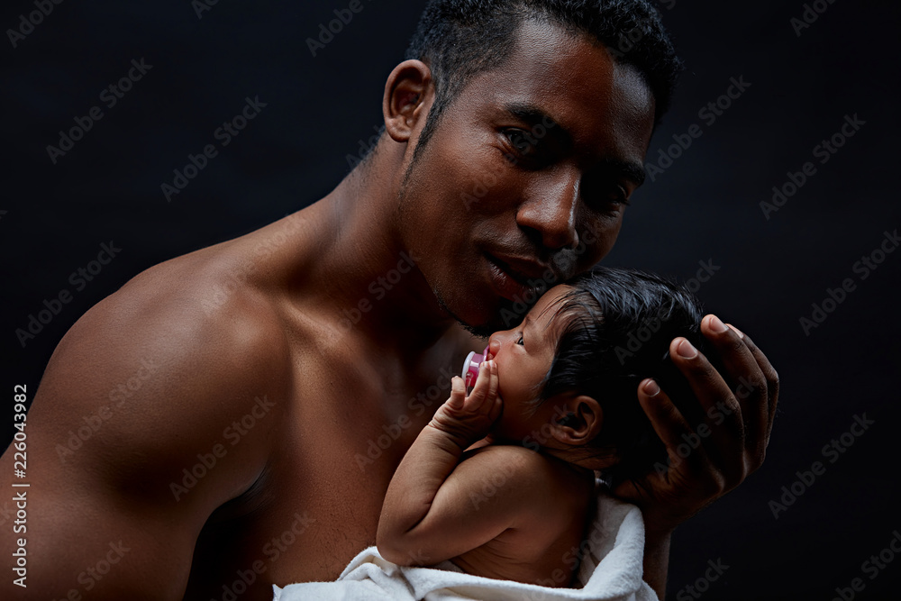 brutal handsome dad is hugging his baby, isolated on the black ...