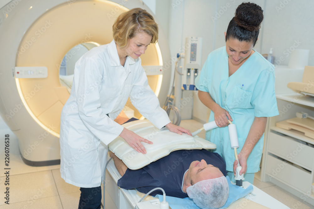 patient undergoes mri scan assisted by two reassuring doctors Stock ...