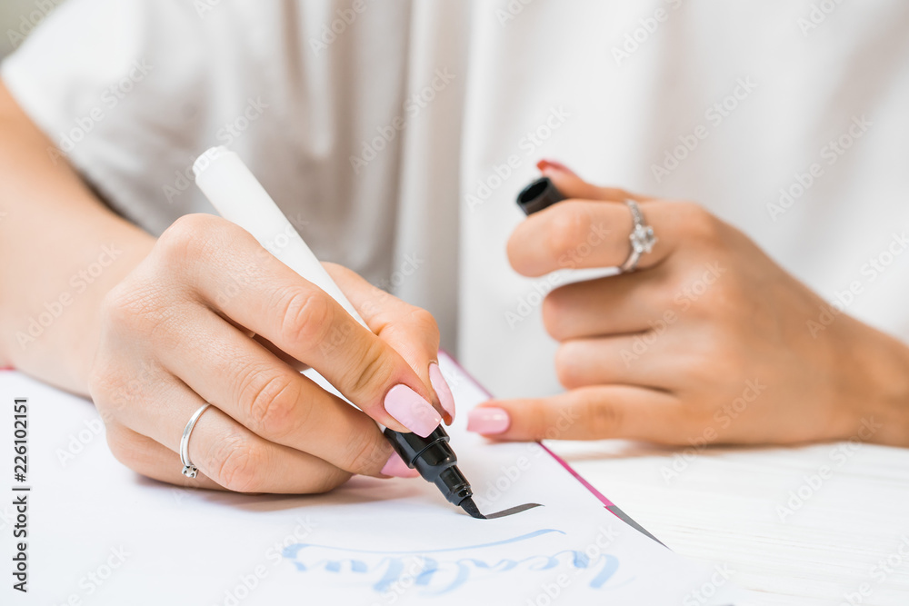 Calligrapher student practices in writing word inspire with green ...