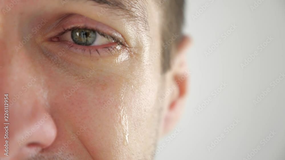 Half face portrait of sad man crying with tears in eye. Man in despair ...