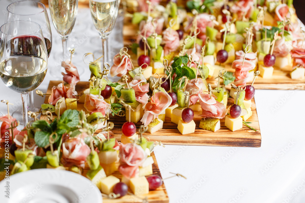 Light snacks in a plate on a buffet table. Assorted mini canapes ...
